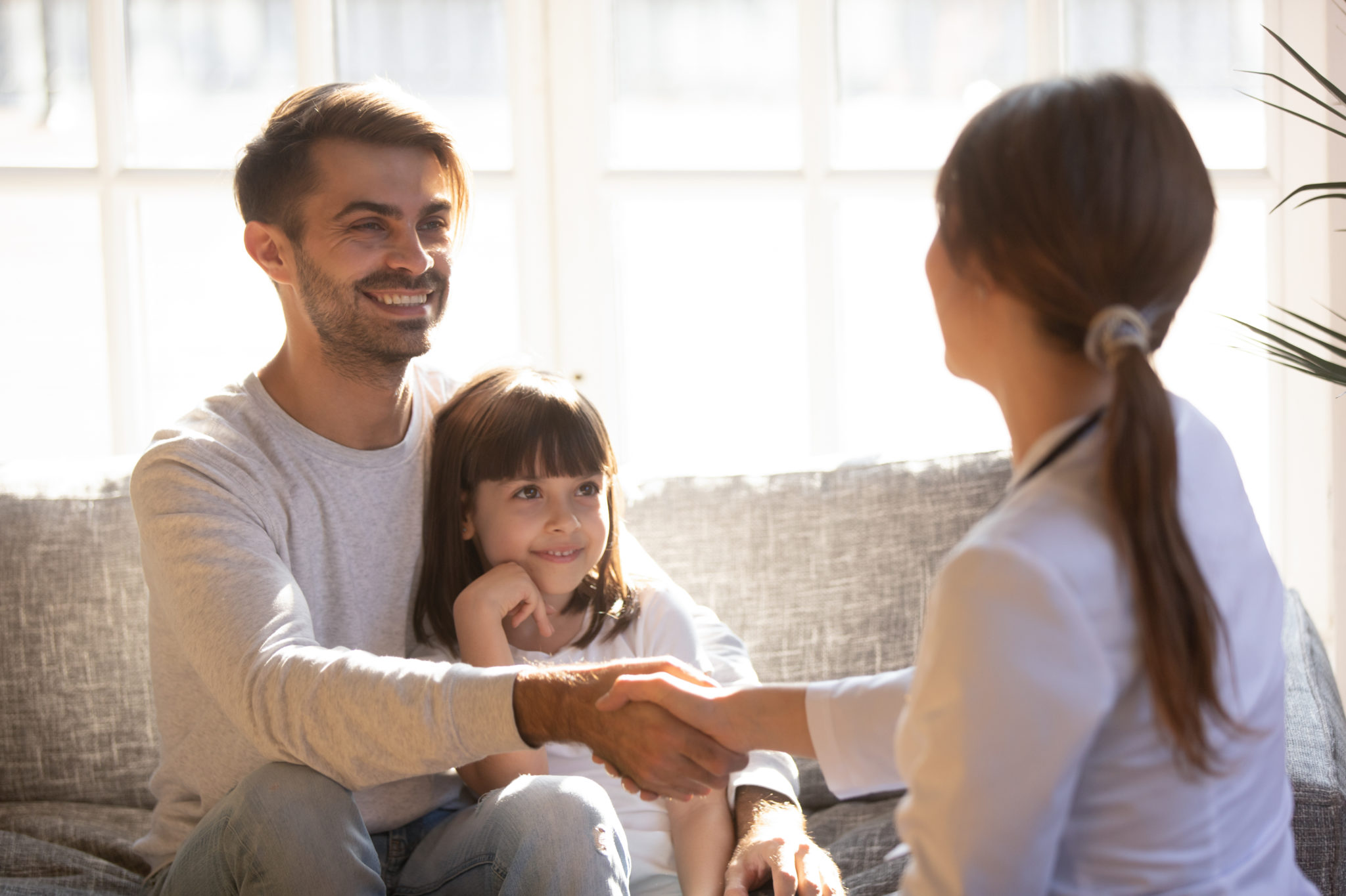 Daughter with father having visit paediatrics handshaking with ...